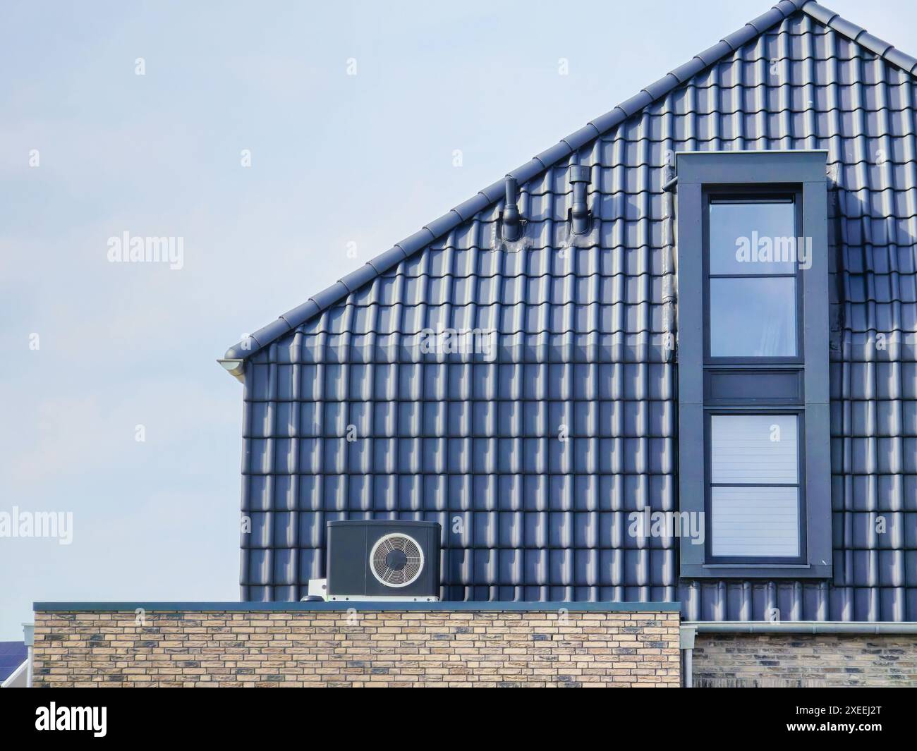 Air source heat pump unit installed outdoors at a modern home with ...