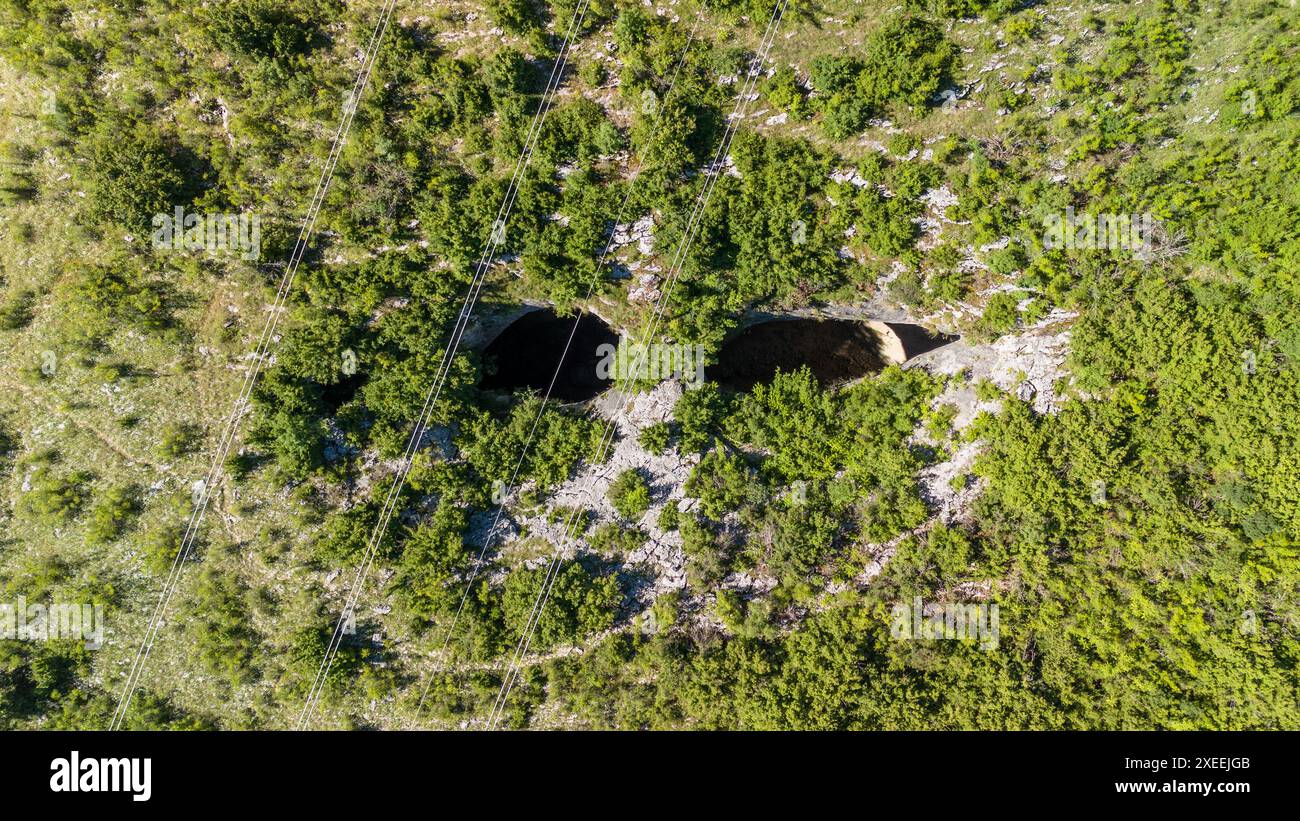 Aerial view of two deep sinkholes in green forest, a natural phenomenon ...