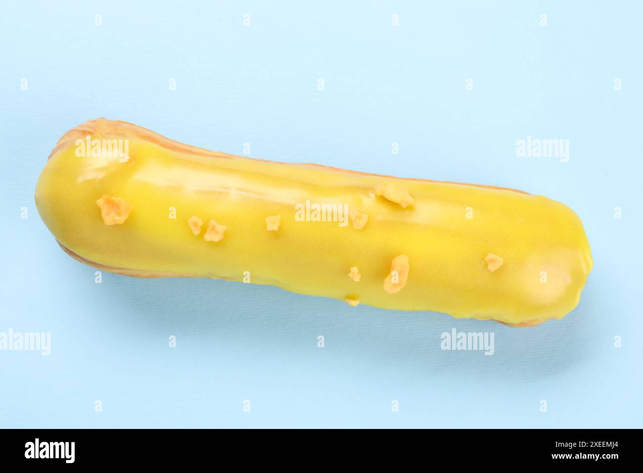 Delicious eclair covered with glaze on light blue background, top view ...