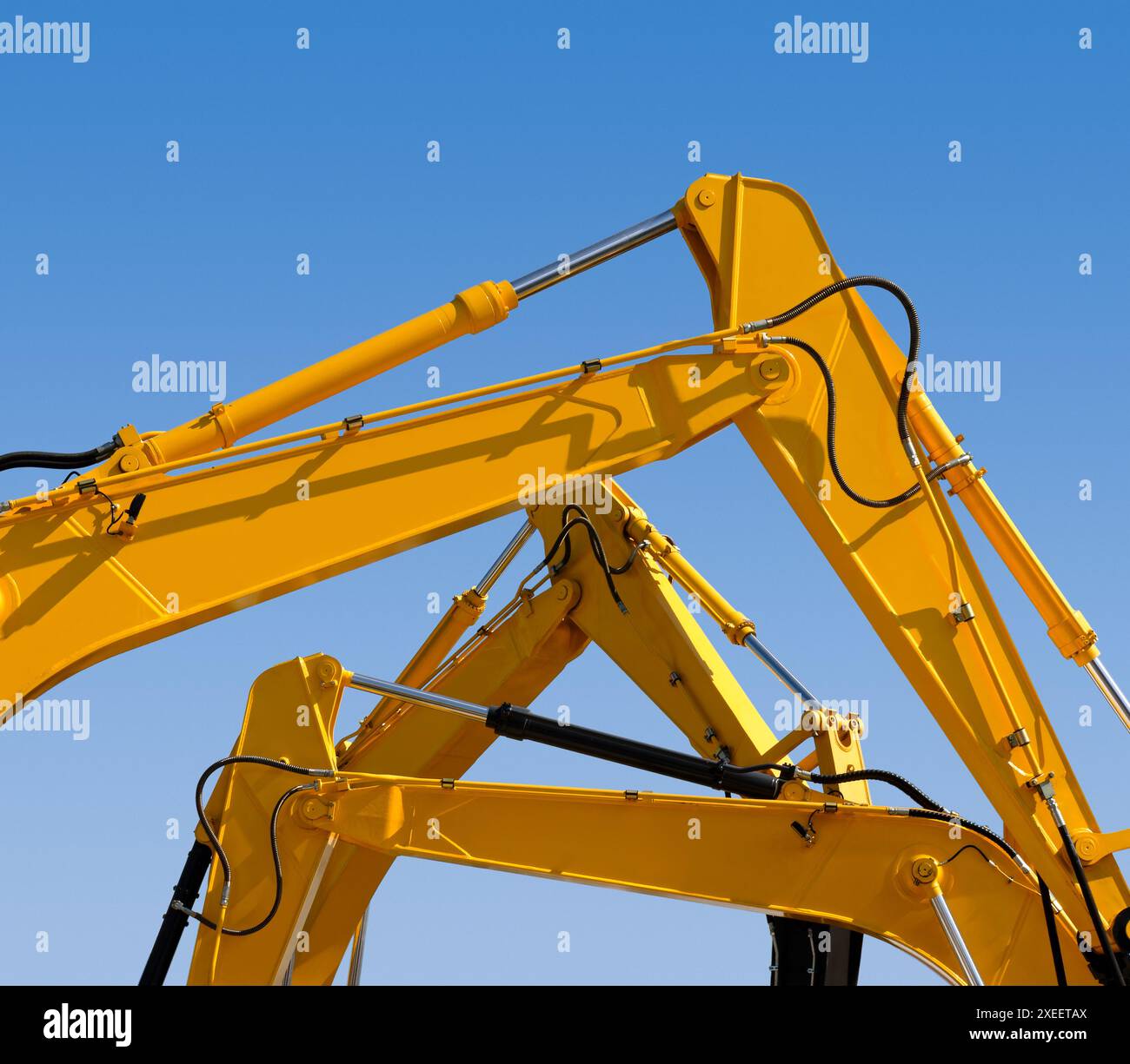 Group of yellow hydraulic arms of an excavator, isolated on clear blue ...