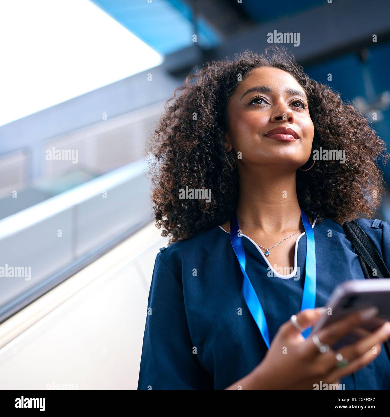 Female Doctor Or Nurse Commuting On Escalator To Platform With Mobile ...