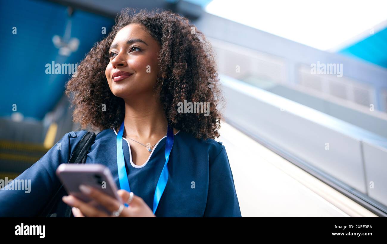 Female Doctor Or Nurse Commuting On Escalator At Railway Station To ...