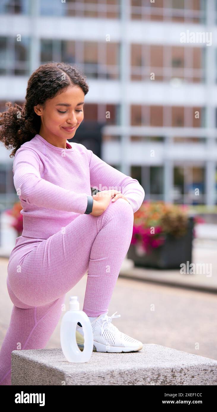 Woman Wearing Fitness Clothing Exercising Outdoors In City Centre Doing ...