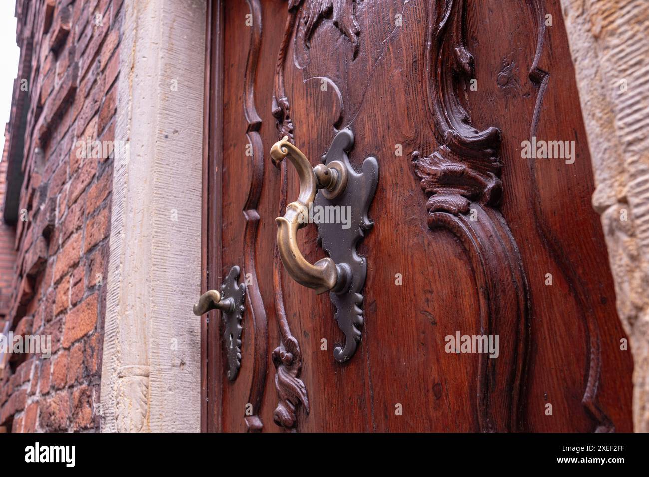 Antique wooden door with gilded handle. Metal door handle close-up ...