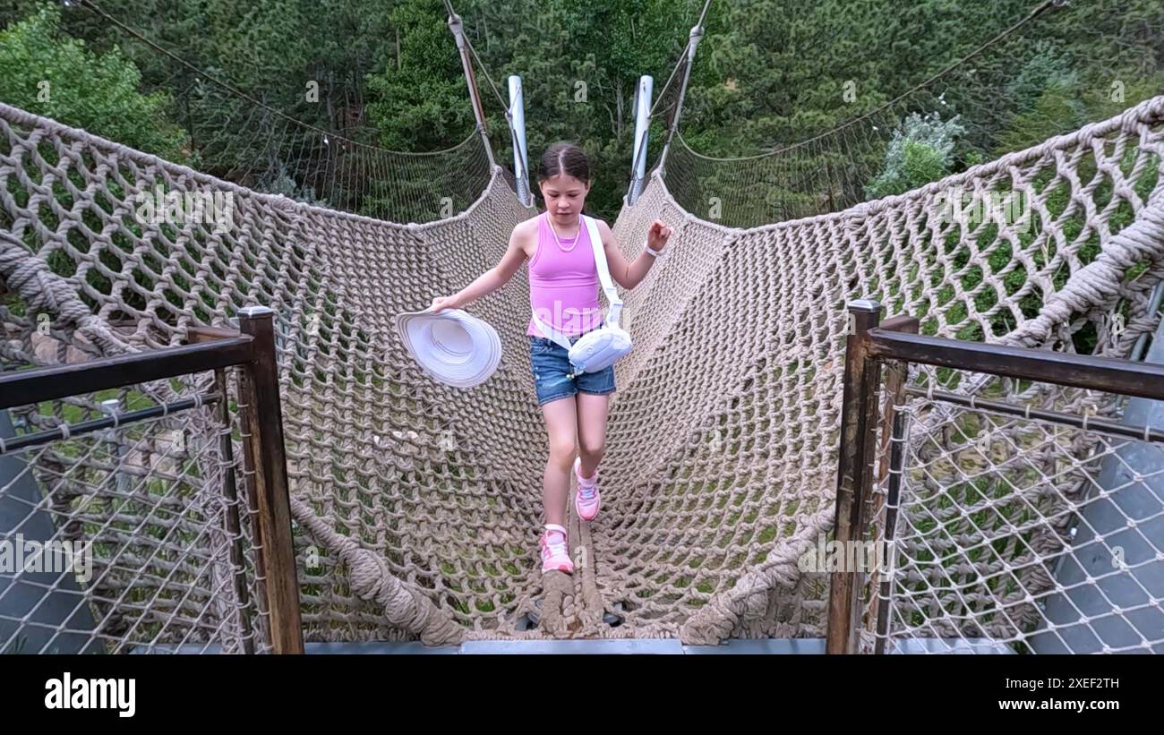 Young Girl Walking Across a Rope Bridge at the Zoo Stock Photo - Alamy