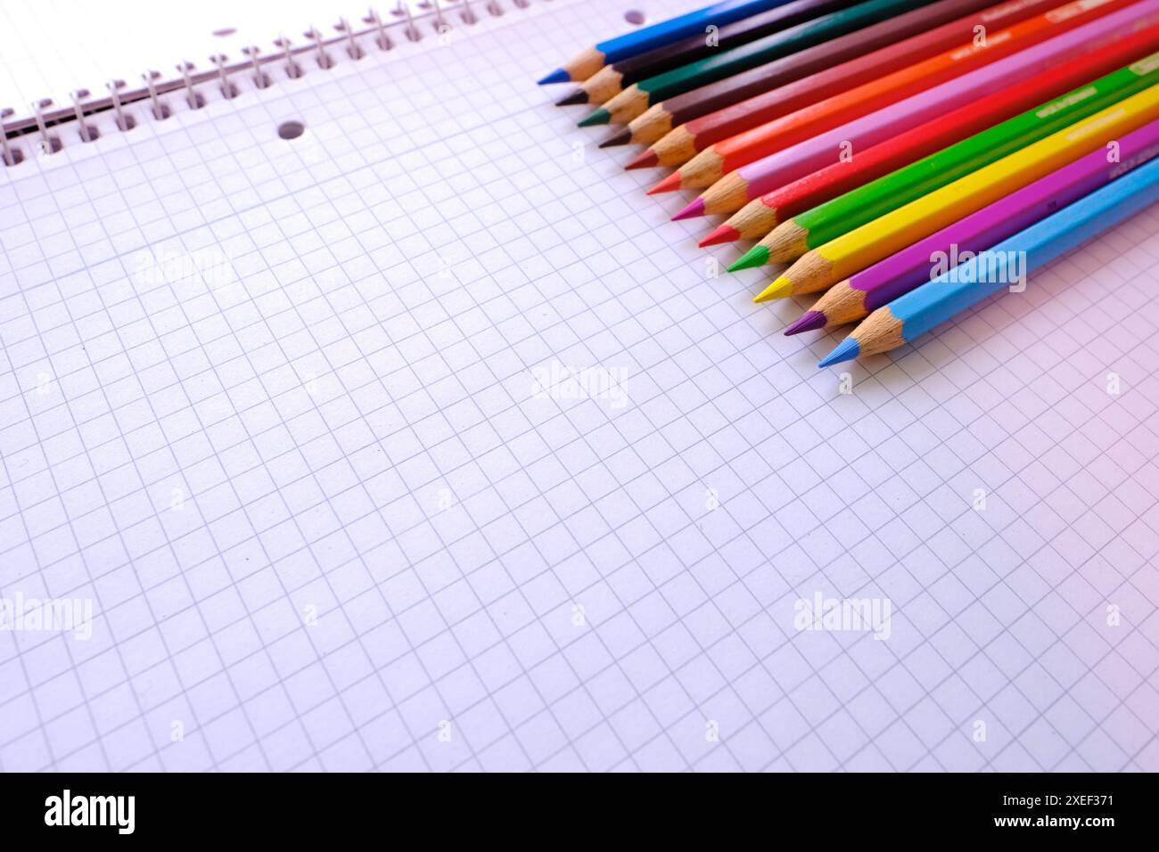 school background, colored pencils lie on a sheet of paper, an open ...