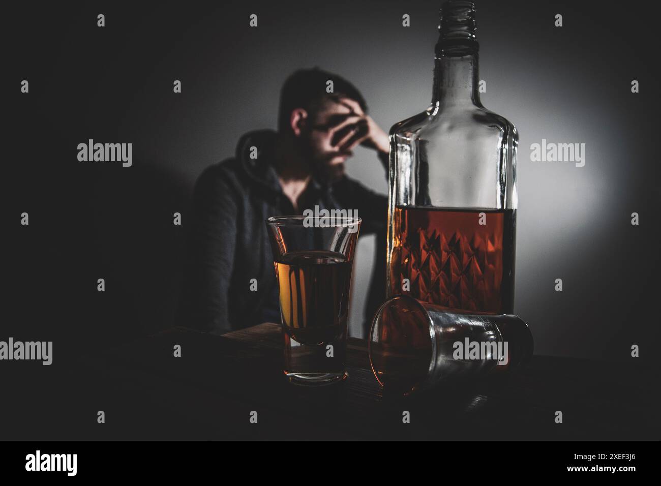 Portrait of lone, depressed, young man regretfully sitting behind a ...
