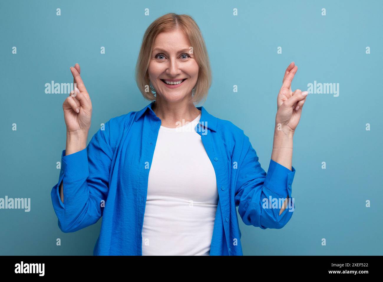 Energetic 50s woman in an attractive look on a blue background with ...