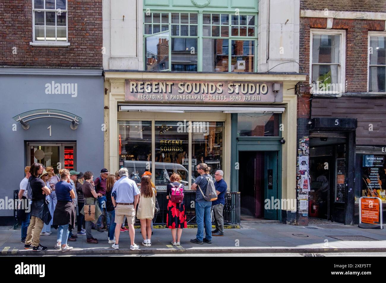 Tourists on London rock music walking tour in Denmark Street, the ...