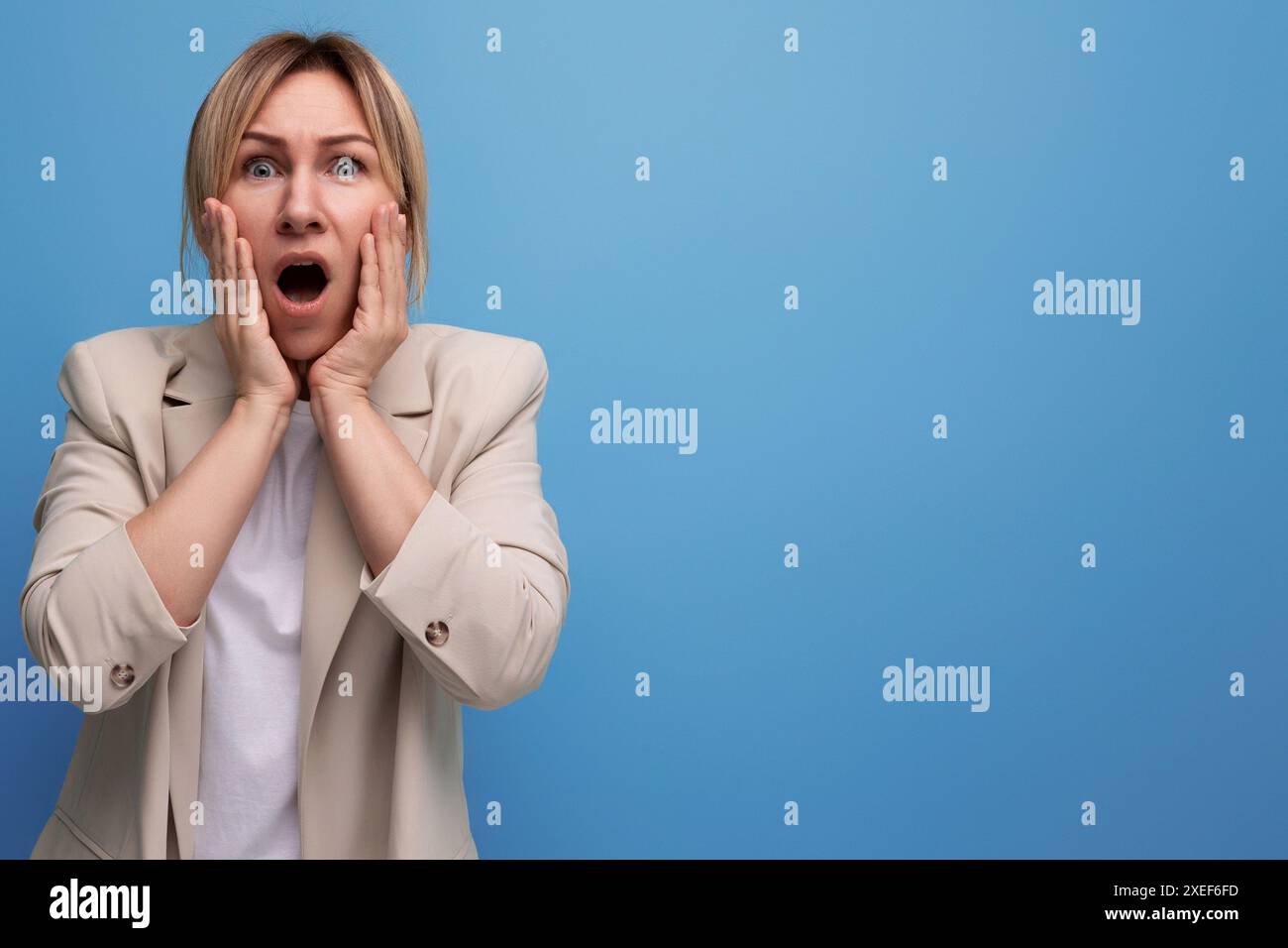 Indignant surprised european young woman in jacket with open mouth on ...