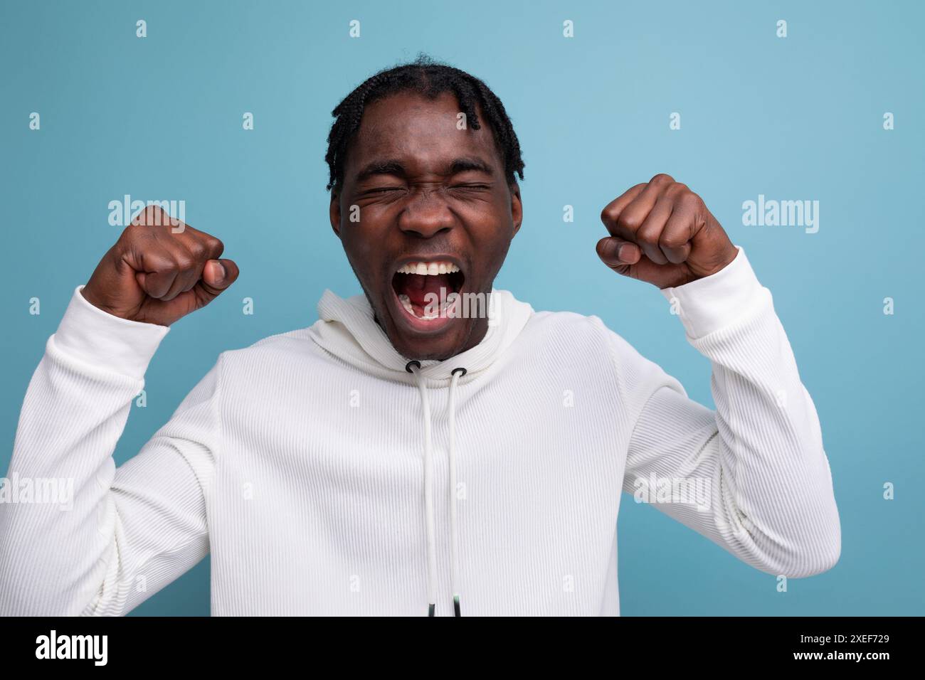 Cute surprised african 20s man with dreadlocks on background with copy ...