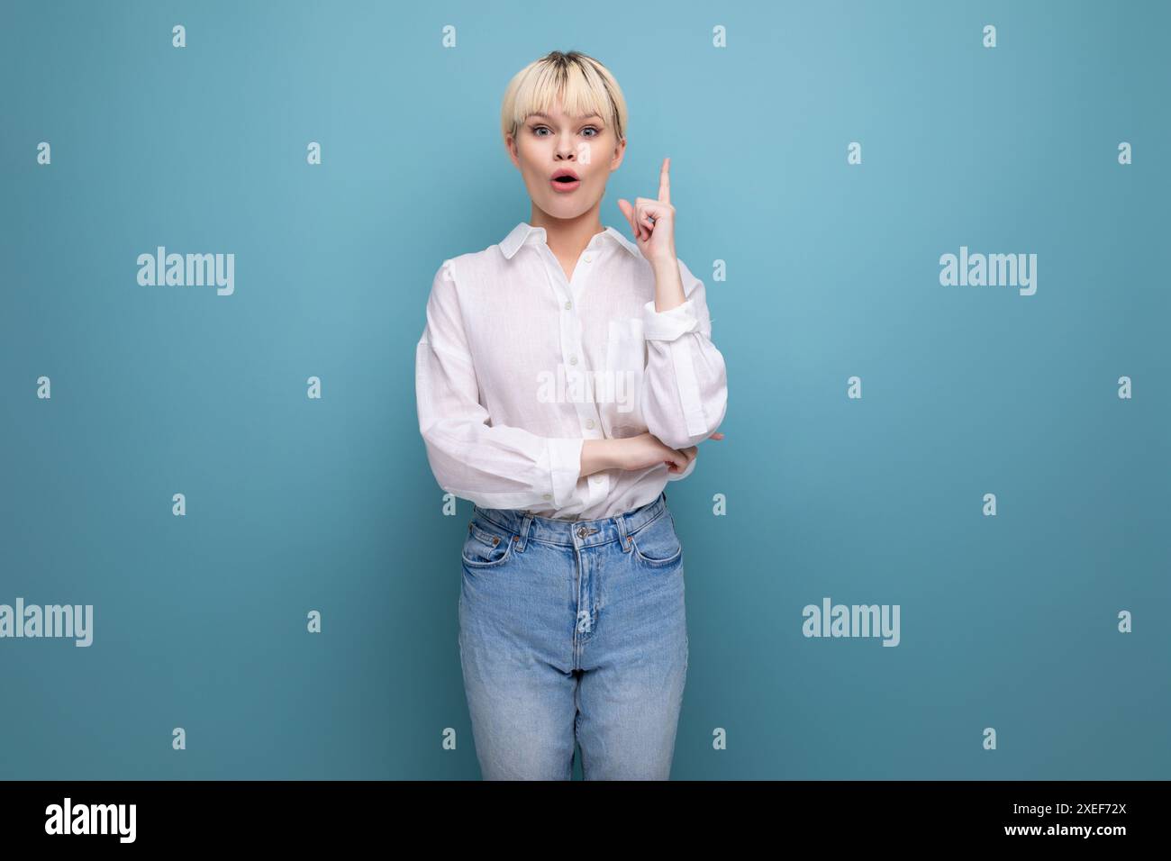 Young smart blonde secretary woman dressed in a white shirt points her ...