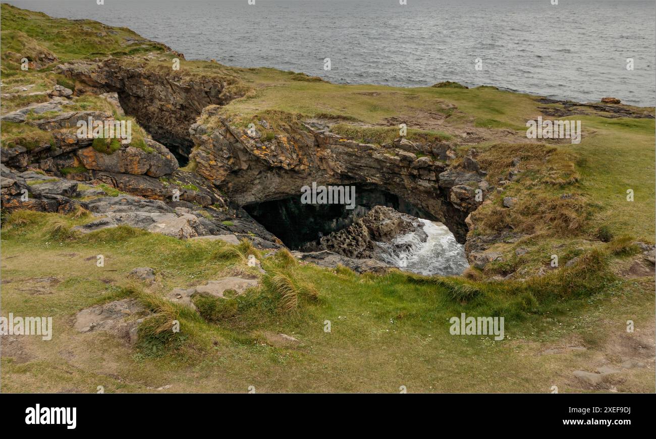 Blow hole creating a fairy bridge on the cliffs of the Atlantic ocean ...