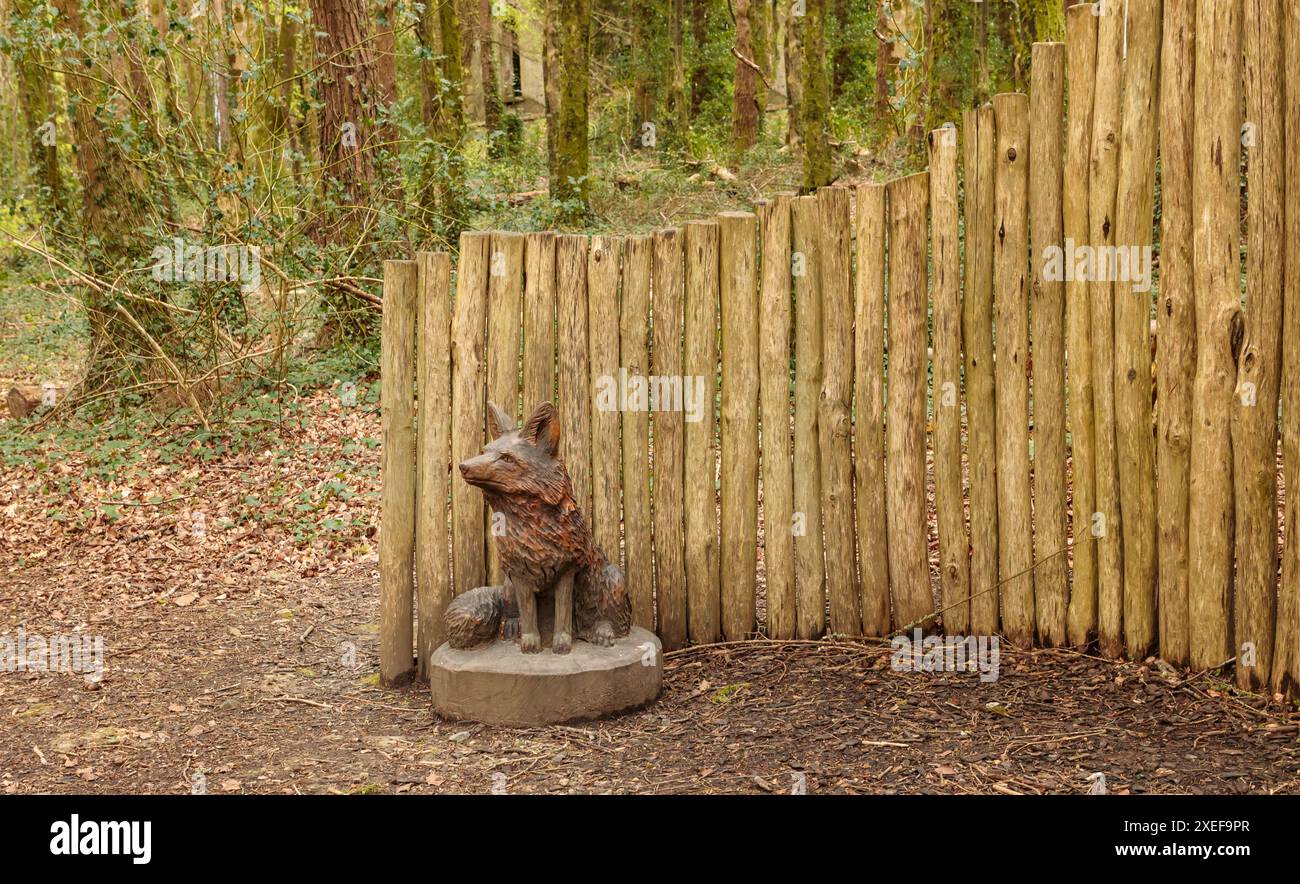 Wooden fox statue next to a wooden fence made of posts Stock Photo - Alamy