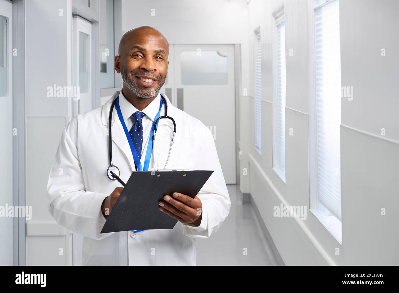 Portrait Of Smiling Mature Doctor Wearing White Coat In Hospital ...