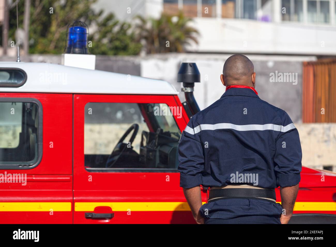 A French firefighter in uniform next to a fire truck parked before the ...