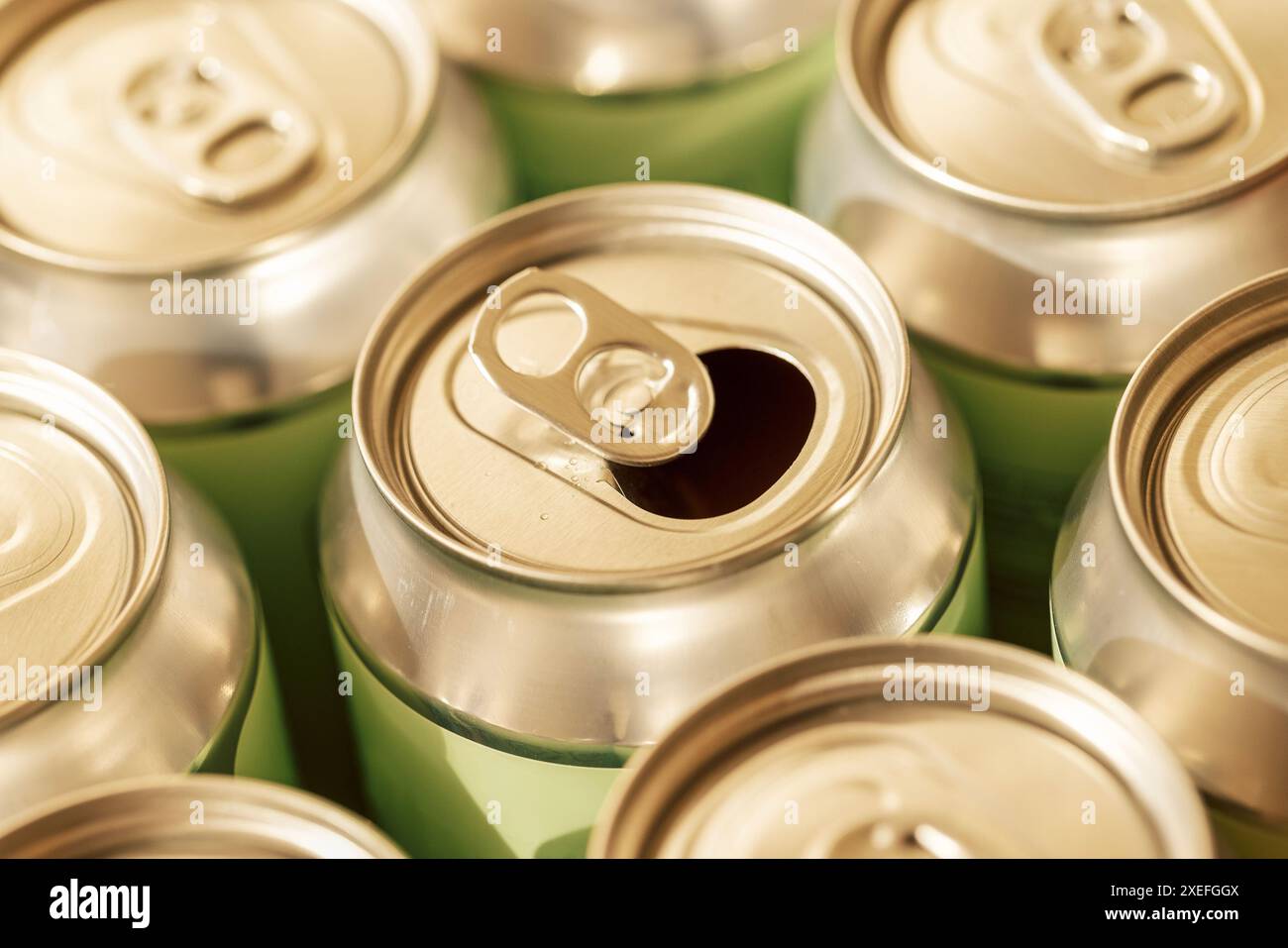 A collection of aluminum cans. One open bottle in the middle. Pattern ...