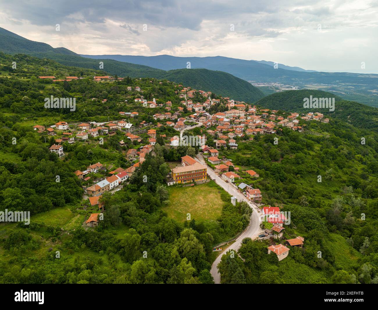 Aerial view of a small mountain village with winding roads, traditional ...