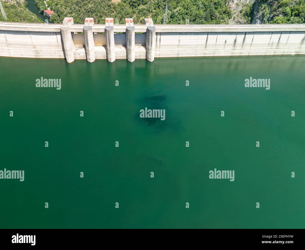 Aerial view of a concrete hydroelectric dam wall holding back a water ...