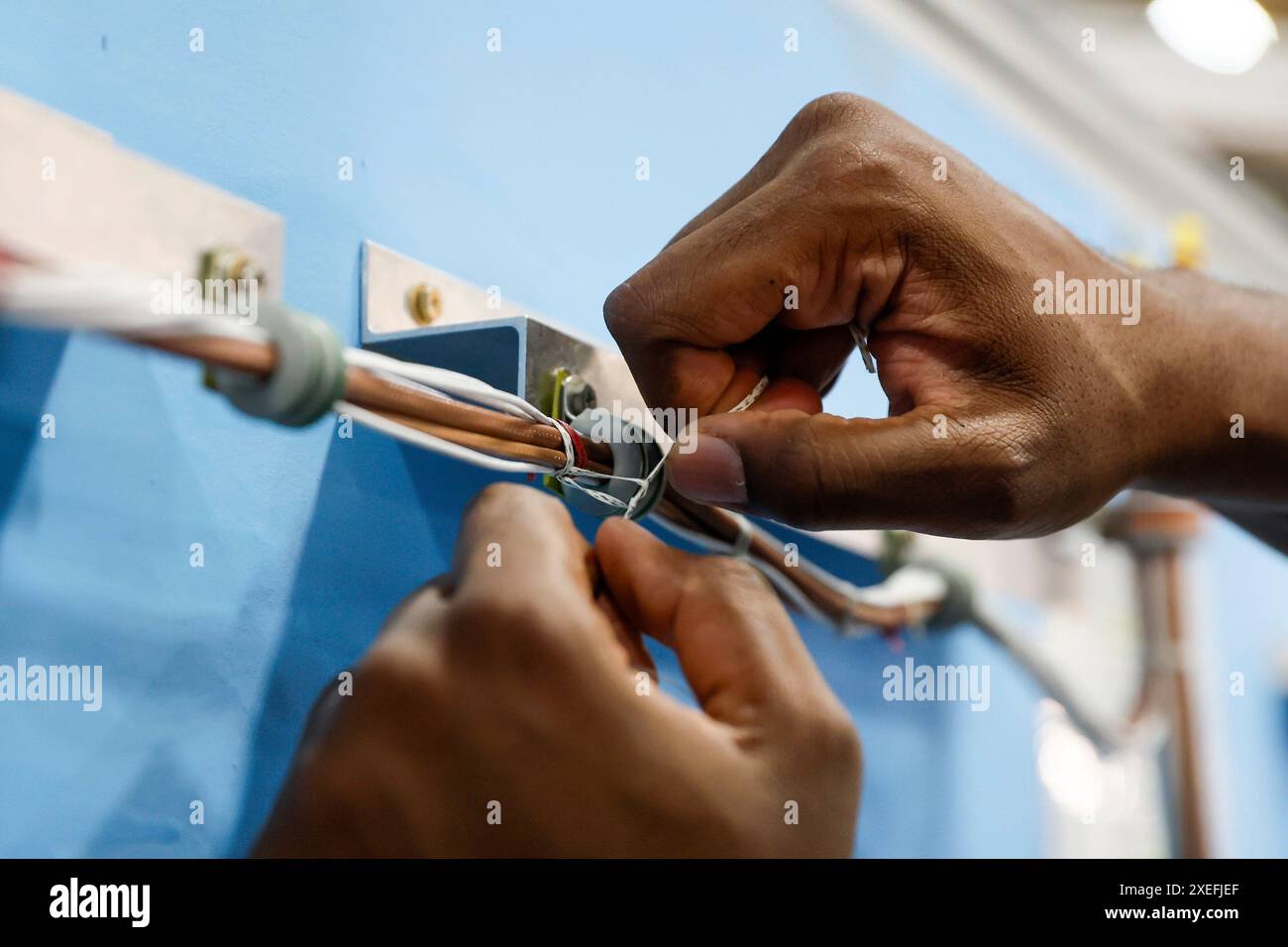 Derrick Farmer ties wires together as he trains on the electrical ...