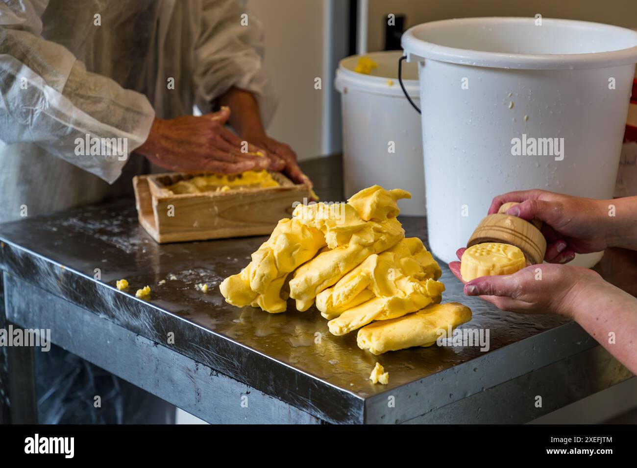 Golden yellow alpine butter is portioned using a traditional wooden ...