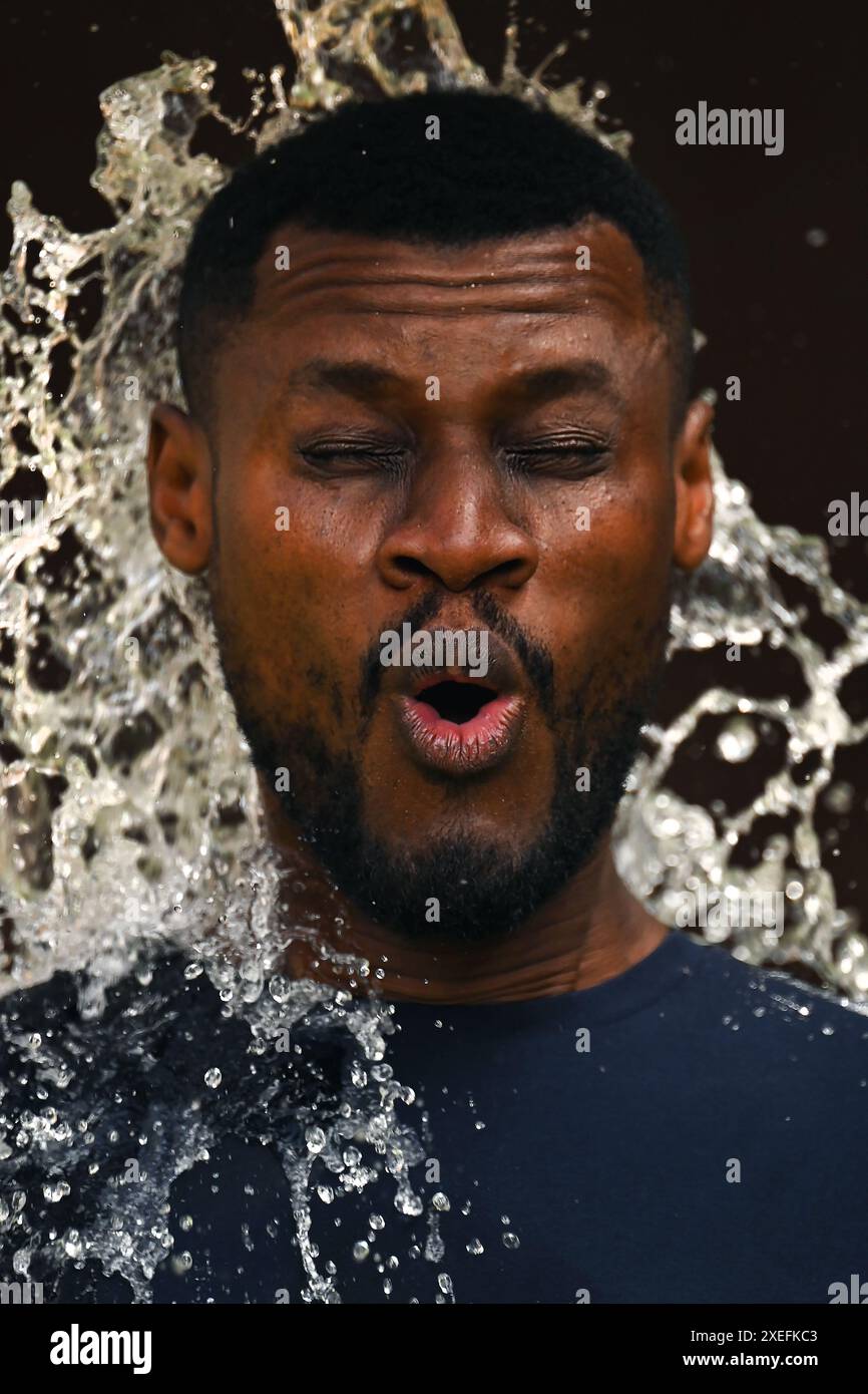 Face of young black man being dunked with cold water on a hot day in ...