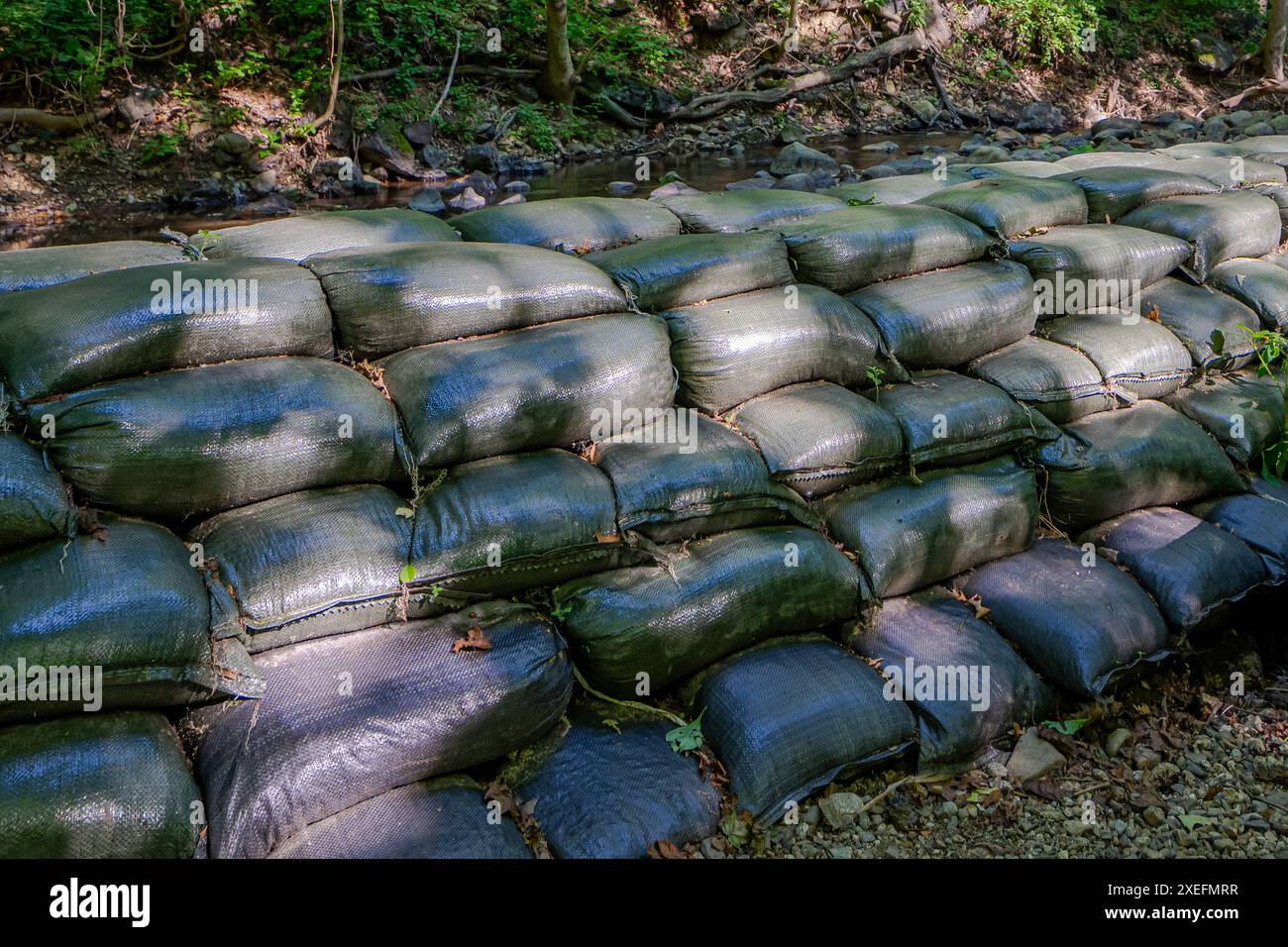 Green nylon sandbags stacked up along a dry stream bed Stock Photo - Alamy