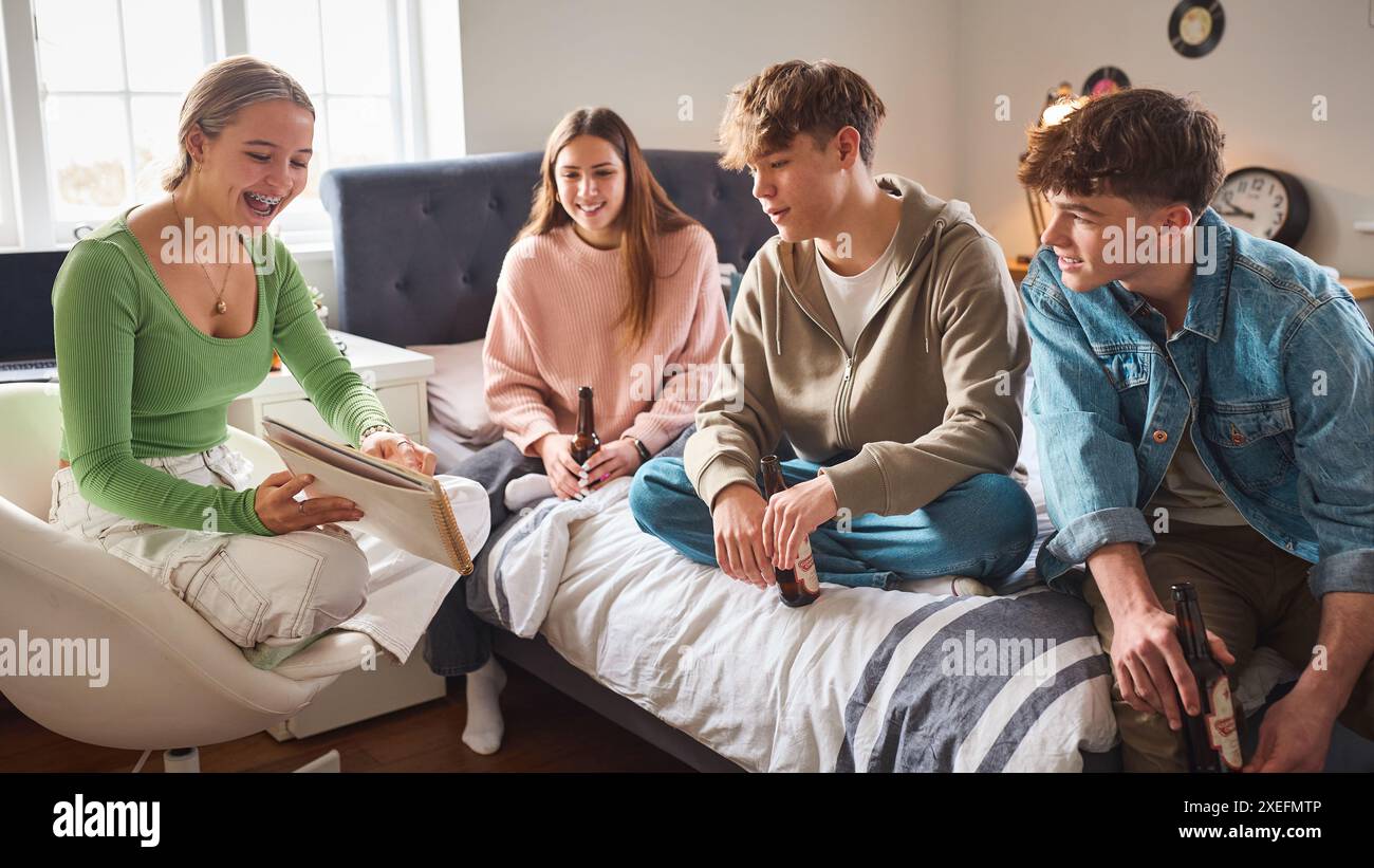 Group Of Teenage Friends At Home In Bedroom Looking At Scrapbook ...
