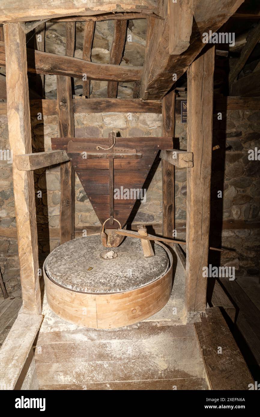 Antique wooden gears grinding wheat in an old watermill inside a stone ...