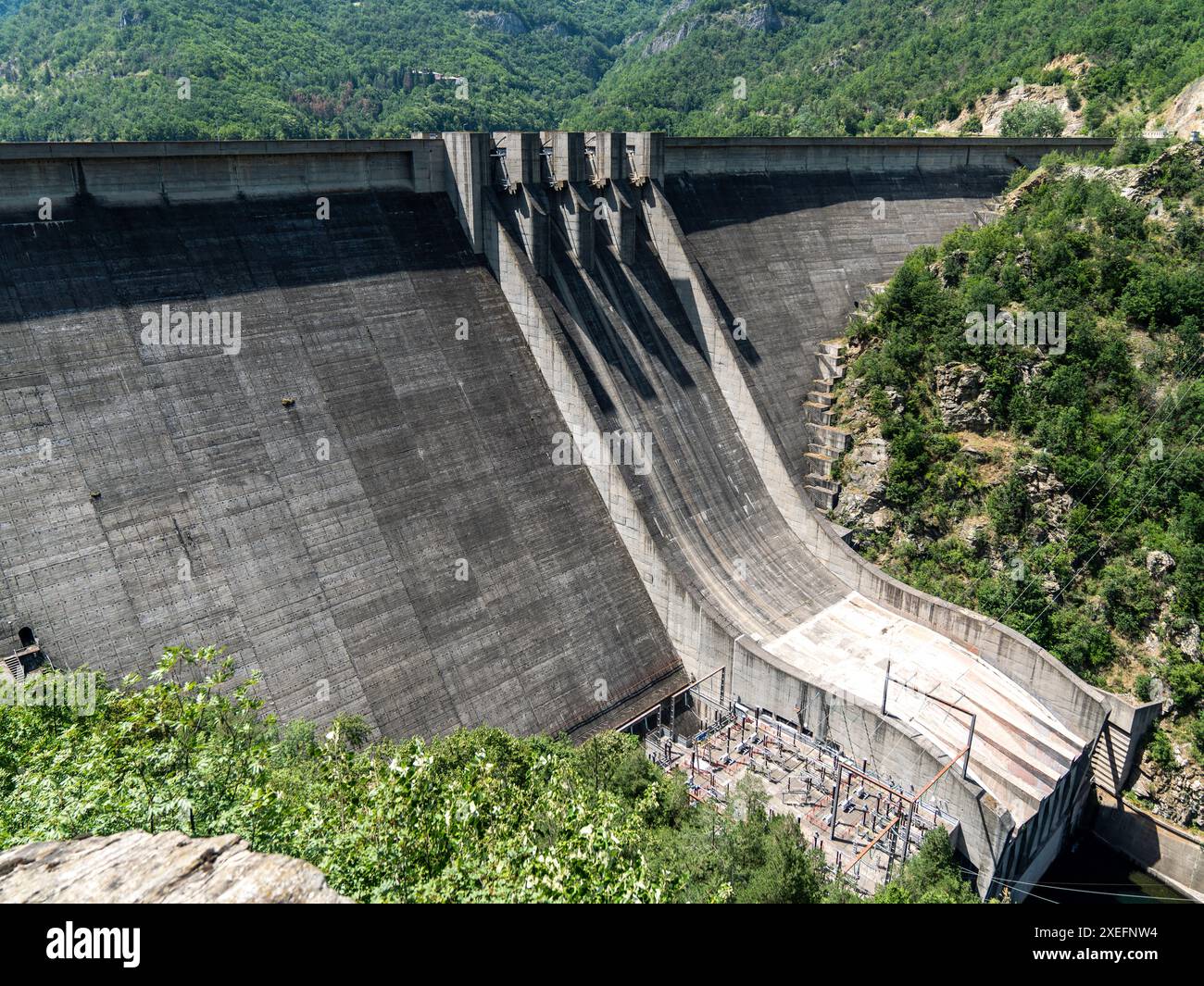 View of a large concrete dam standing tall and imposing in a rugged ...