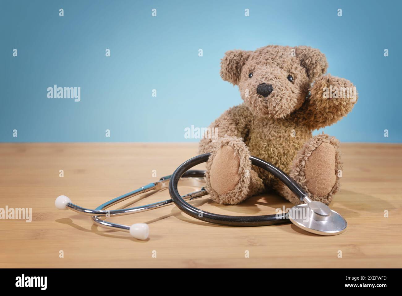 Cute little teddy bear sitting on the table with a stethoscope and ...