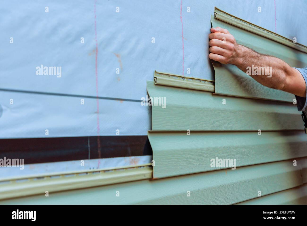 Installation of vinyl siding plastic panels on facade wall new home by ...