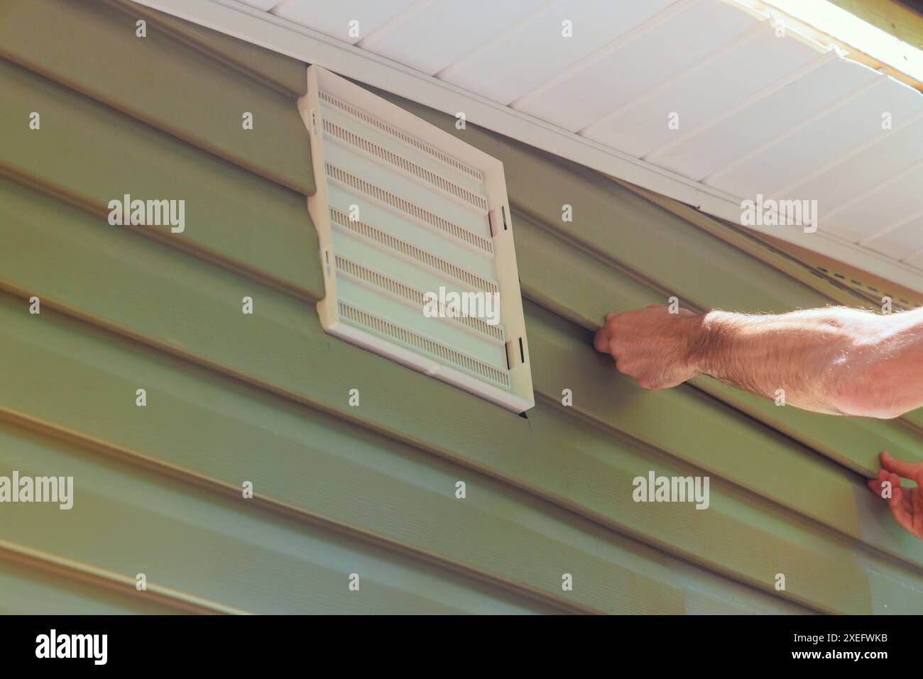 Wall facade of new house is covered with vinyl plastic siding panels ...