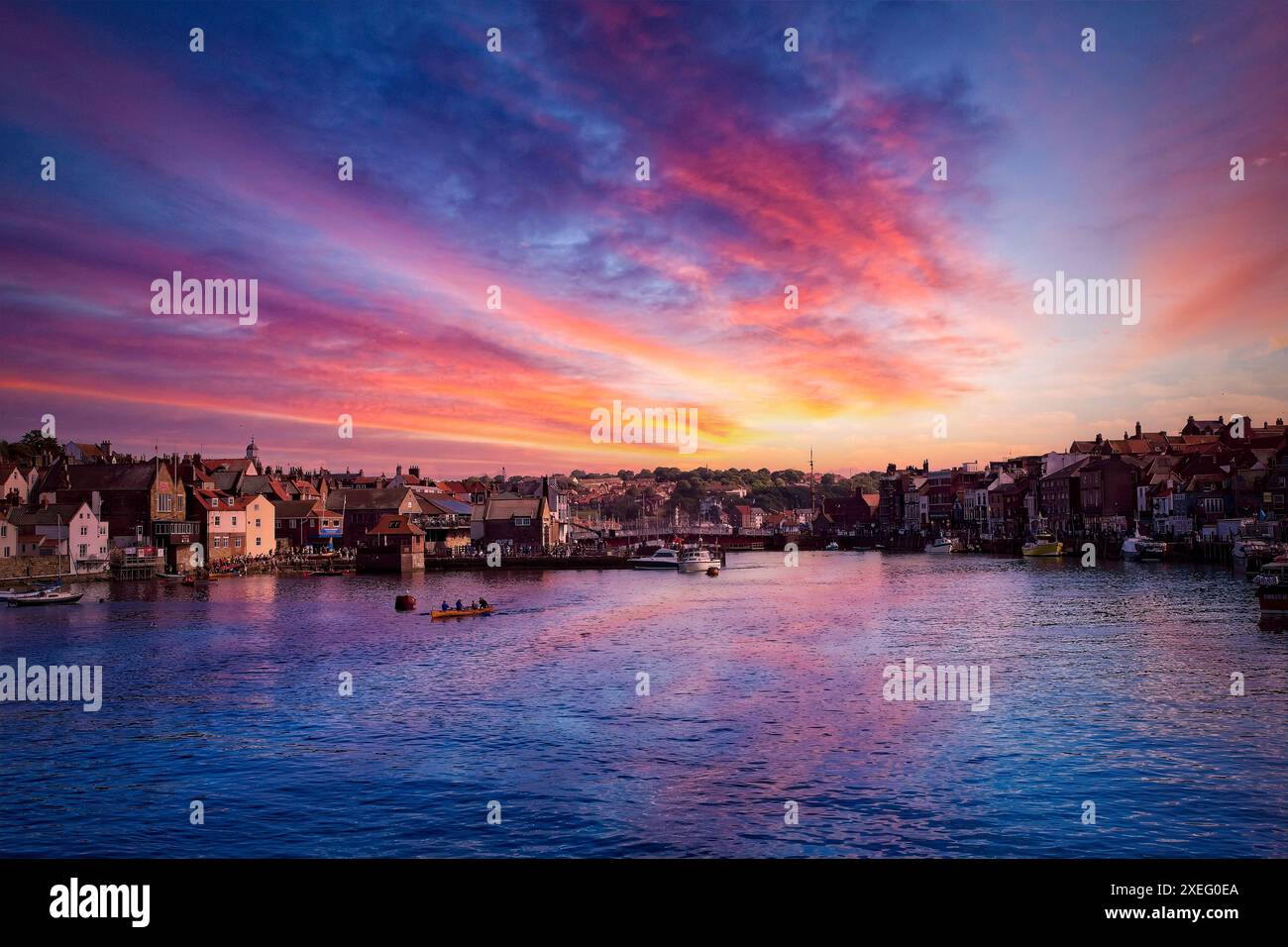 A picturesque harbor at sunset with colorful skies and calm waters ...