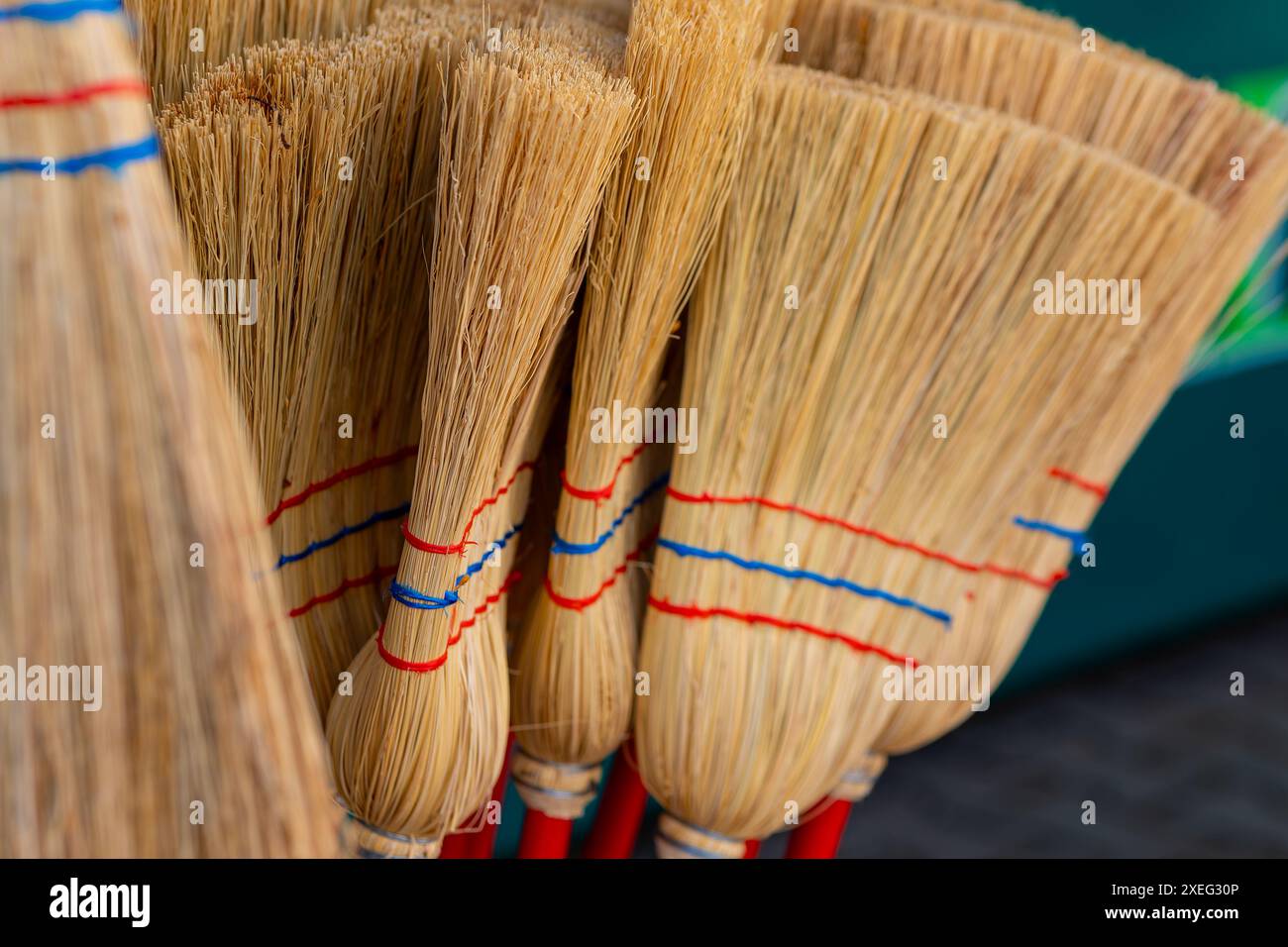 Bunch of brooms with red and blue stripes Stock Photo - Alamy