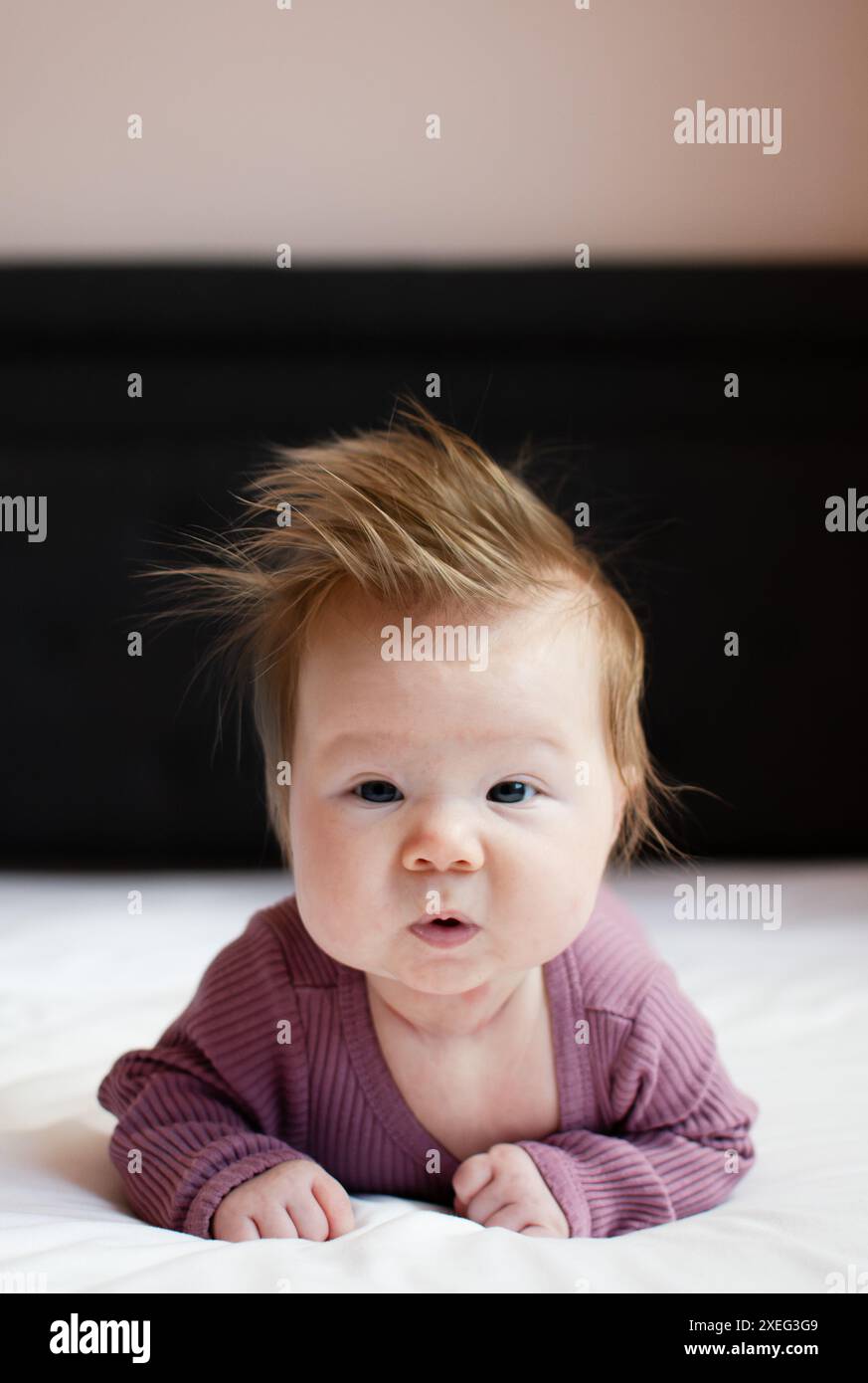 Little Caucasian newborn baby girl during tummy time looking at the ...