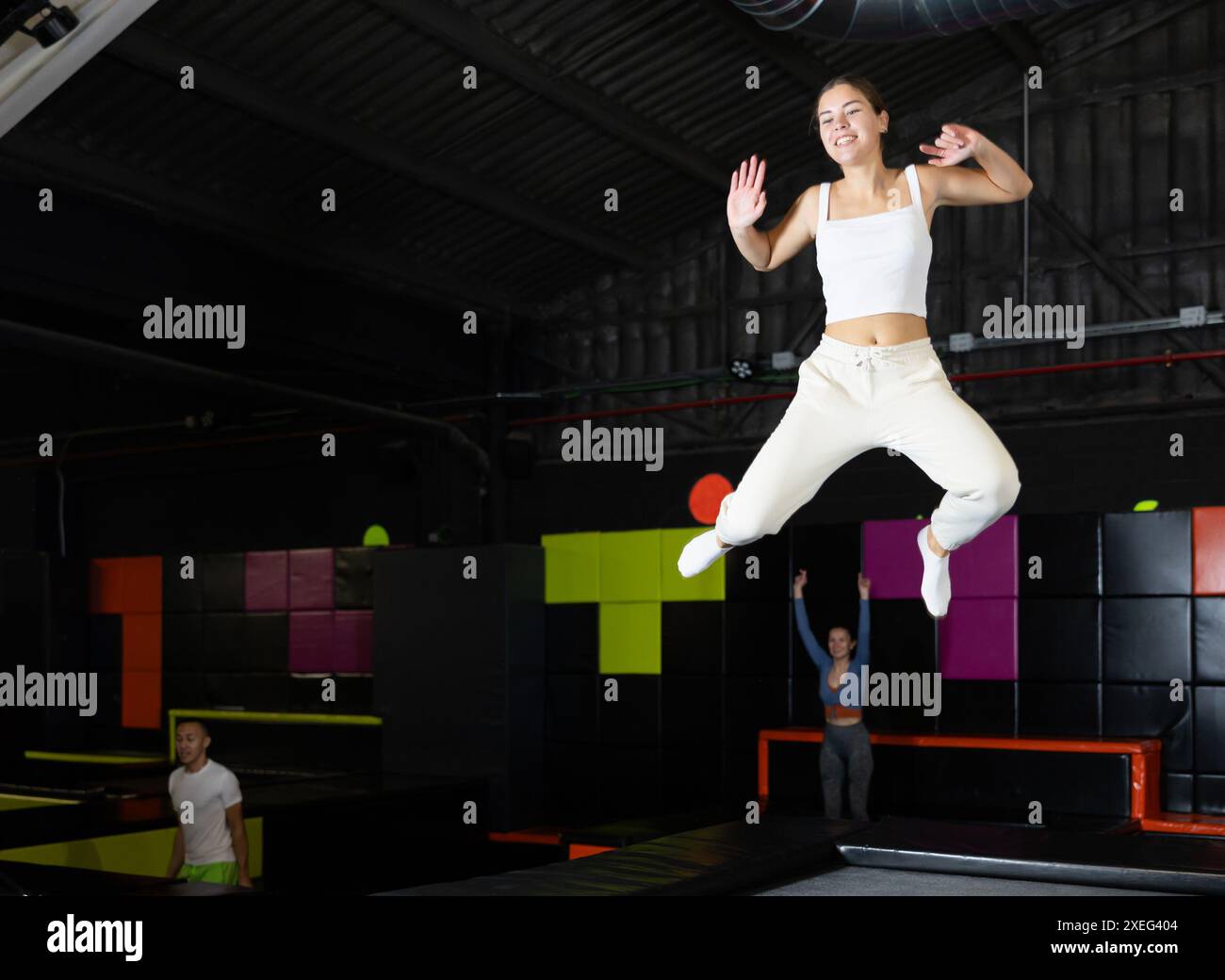Happy girl bouncing on trampoline in indoor amusement park Stock Photo ...