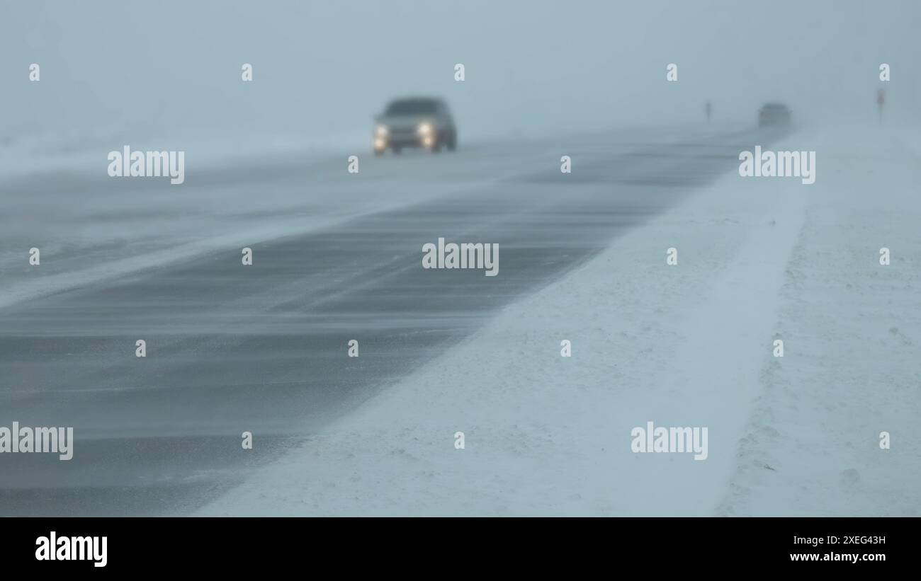 Cars on winter road at blizzard Stock Photo - Alamy