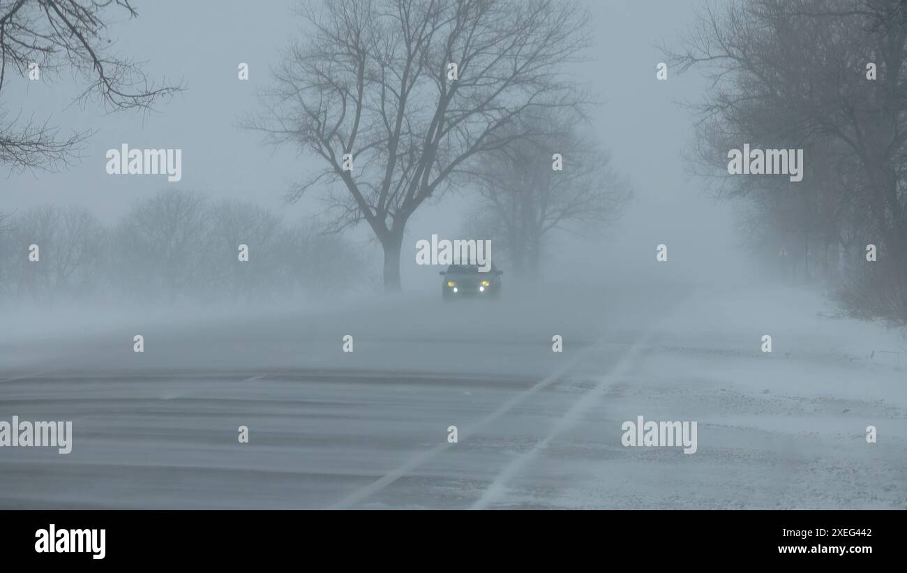 Cars on winter road at blizzard Stock Photo - Alamy