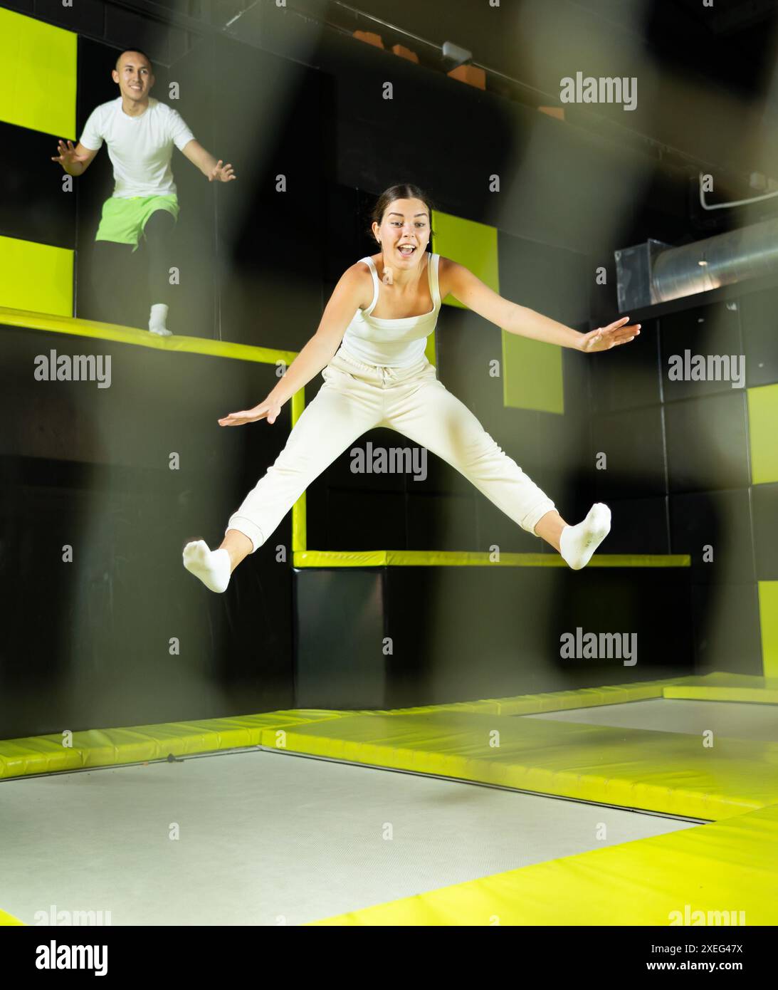 Happy girl bouncing on trampoline in indoor amusement park Stock Photo ...