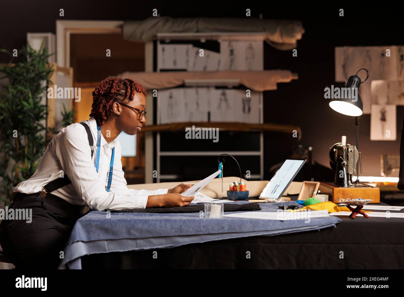 Expert fashion designer looking over bespoken sartorial collection ...