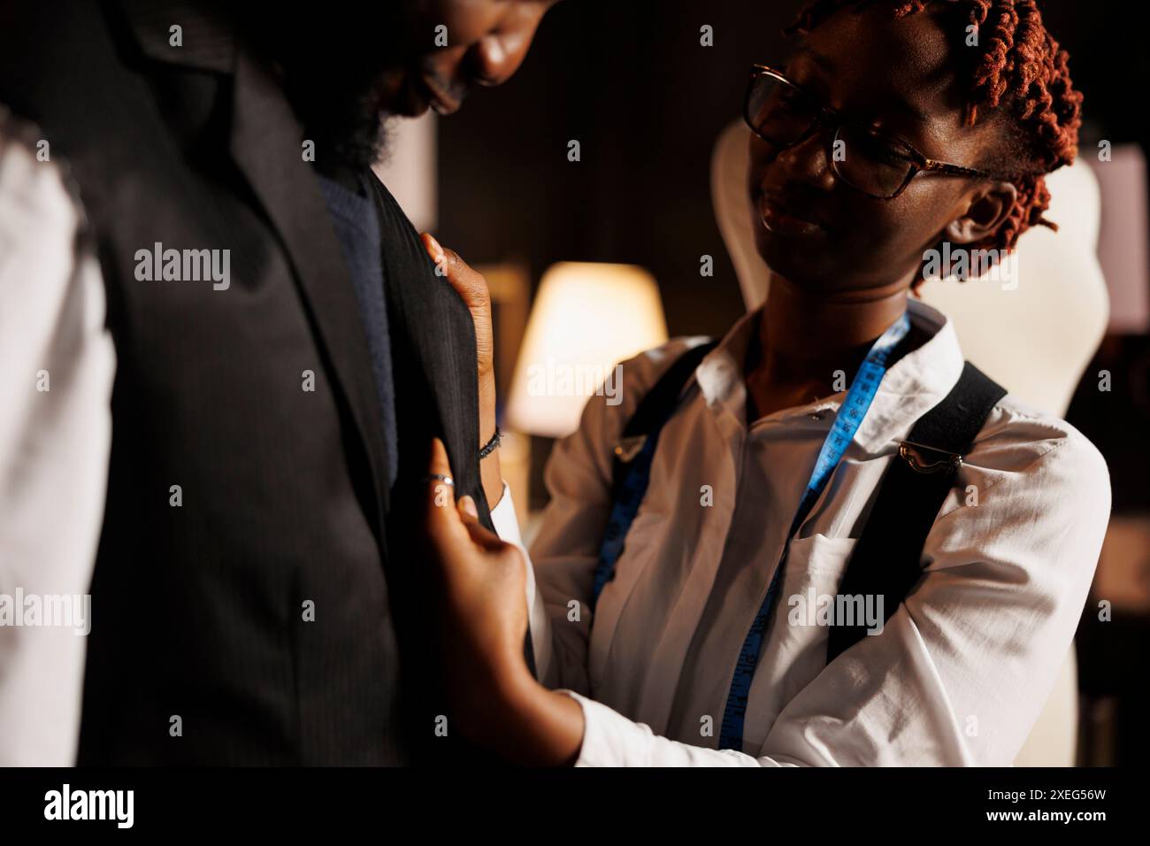 Seamstress helping well dressed gentleman try on premium quality ...