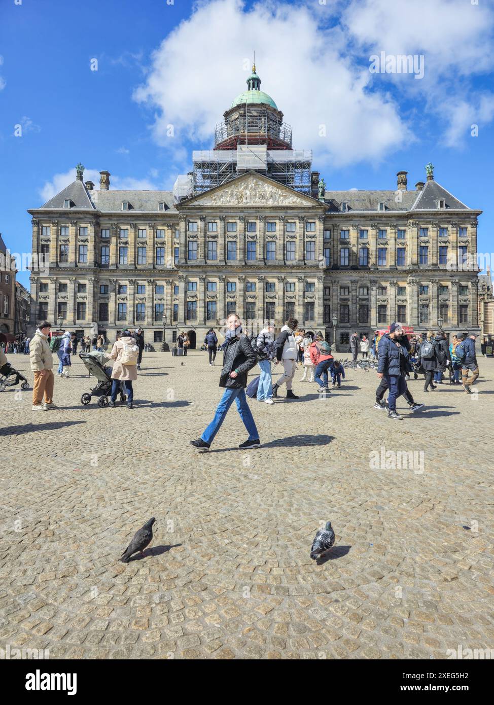 A diverse group of people wander aimlessly in front of a colossal ...