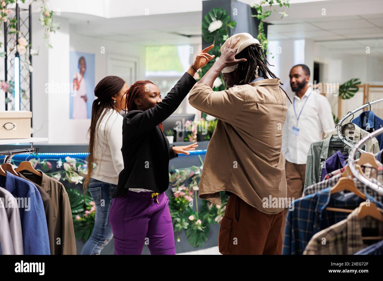 Stylish african american friends trying on hat and having fun together ...