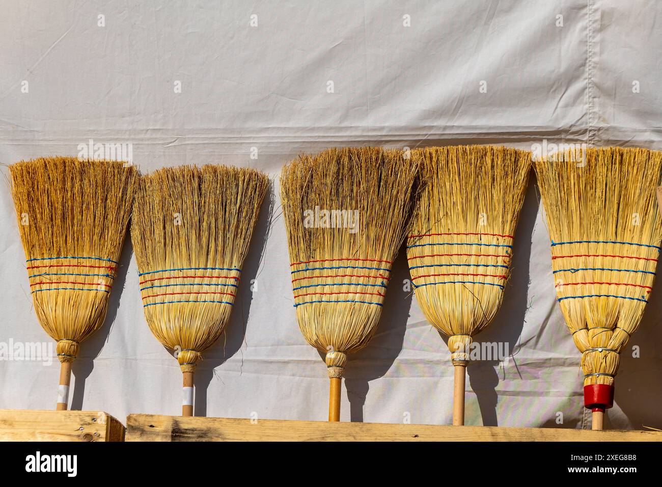 Bunch of brooms with red and blue stripes Stock Photo - Alamy