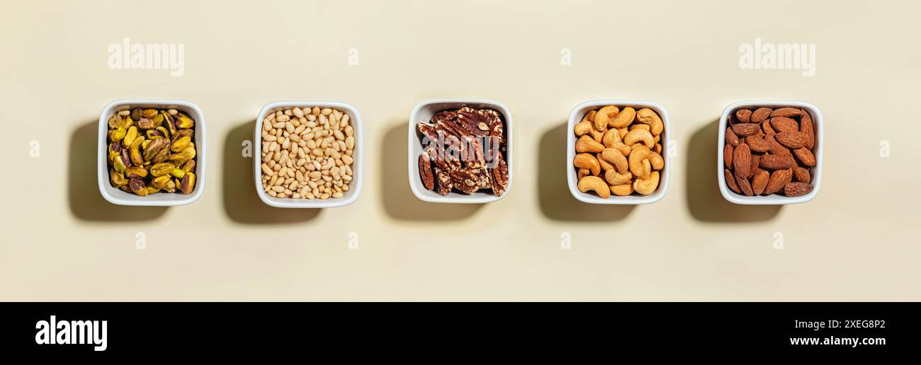 Various types of dry nuts in a small bowls, overhead view. Healthy fat ...
