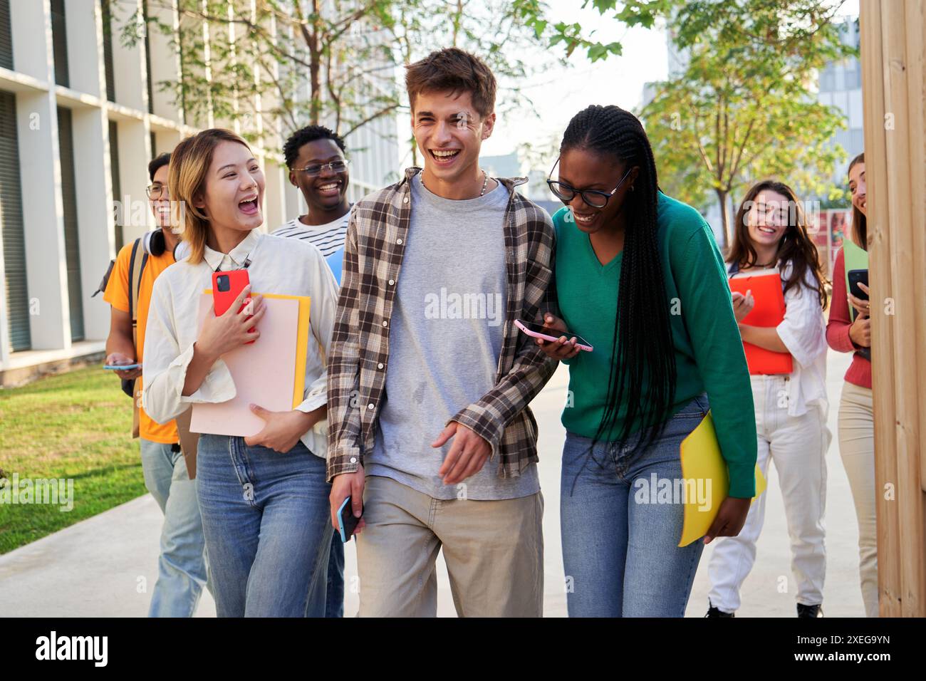 Cheerful group of multi-ethnic students walking towards the camera ...