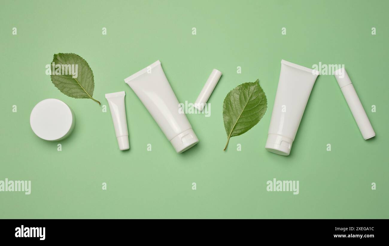 White plastic tubes, jars, and containers for cosmetic products on a ...