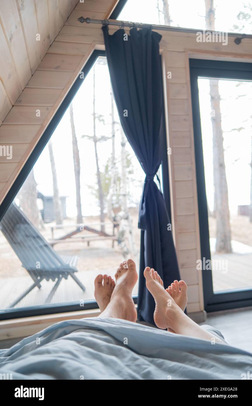 The feet of a married couple sticking out from under the blanket in a ...