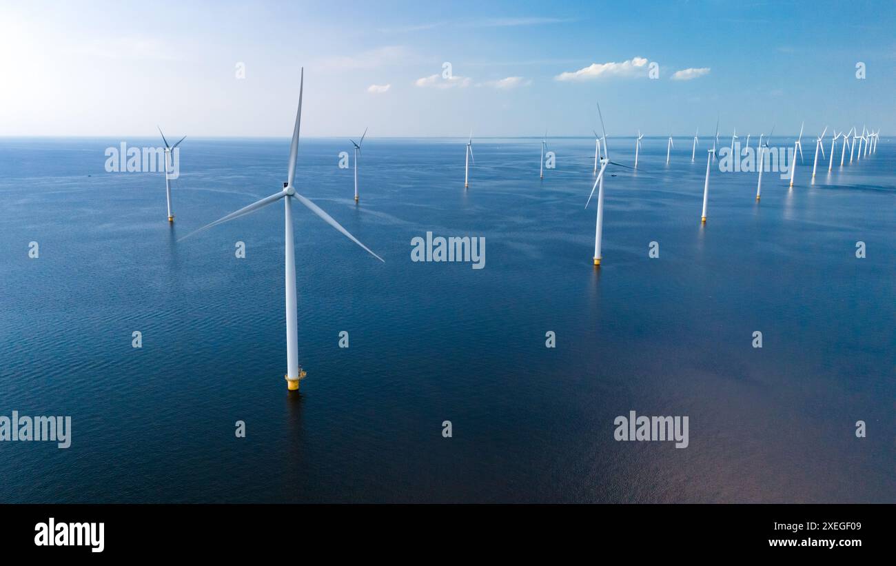 A vast expanse of wind turbines scattered across the ocean, their blades turning gracefully in ...